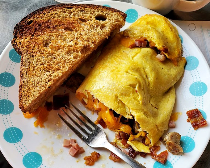 An omelet that's essentially a meat department with eggs as the binding agent. Protein paradise on a plate with perfectly golden toast standing guard.