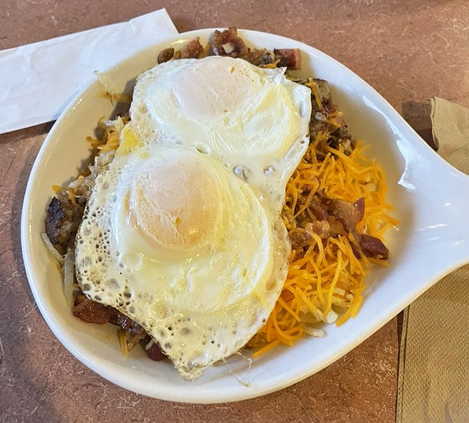 Two sunny-side up eggs crowning a mountain of breakfast potential. This skillet doesn't just feed you&mdash;it fuels adventures across Missouri's highways and byways.