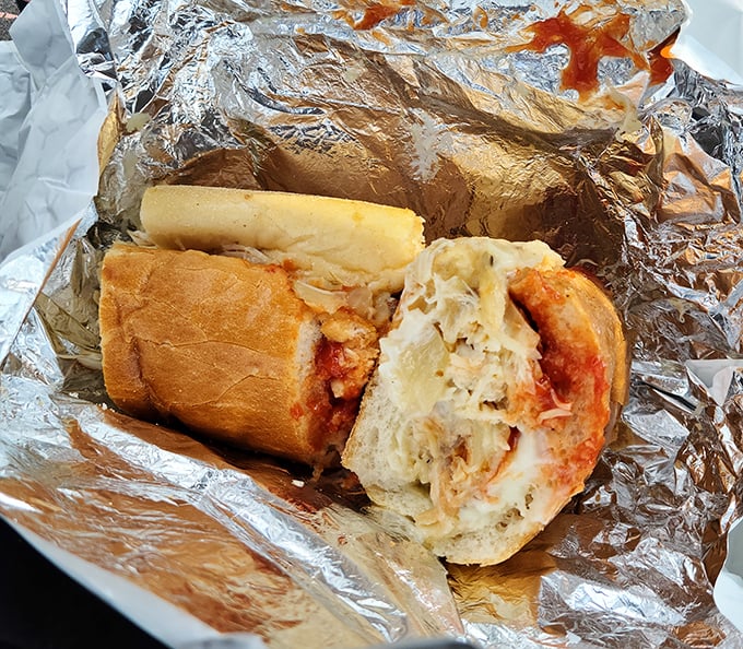 The meatball sandwich arrives like a saucy declaration of Italian-American pride. Those red stains on the foil? Badges of honor in the sandwich universe.