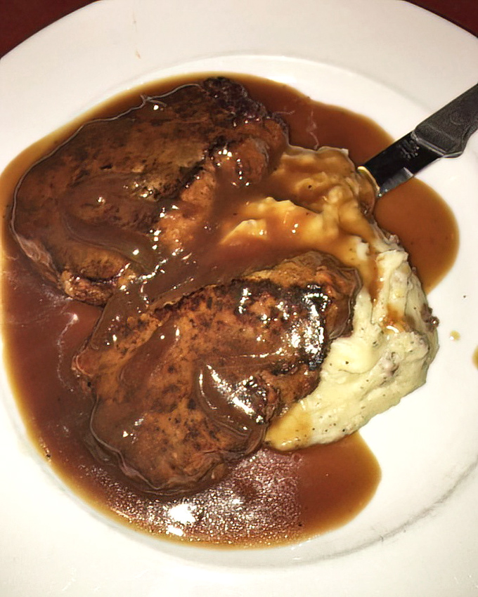 Meatloaf swimming in rich gravy alongside cloud-like mashed potatoes. Comfort food that hugs you from the inside out.