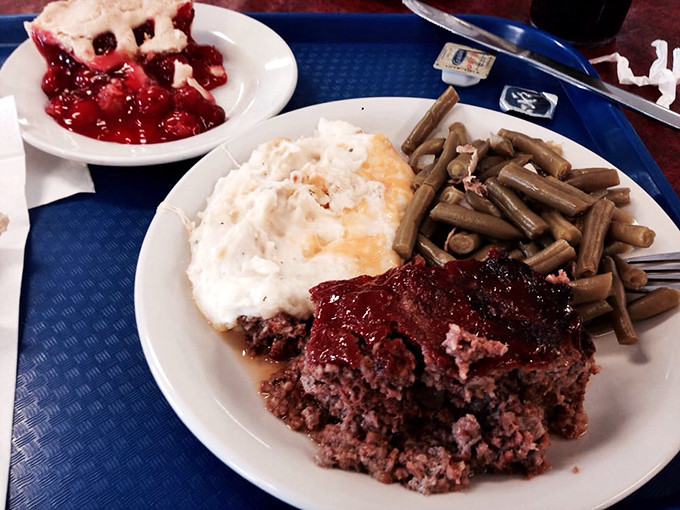 Meatloaf and mashed potatoes sharing plate space with green beans, proving comfort food doesn't need to be complicated to be perfect.