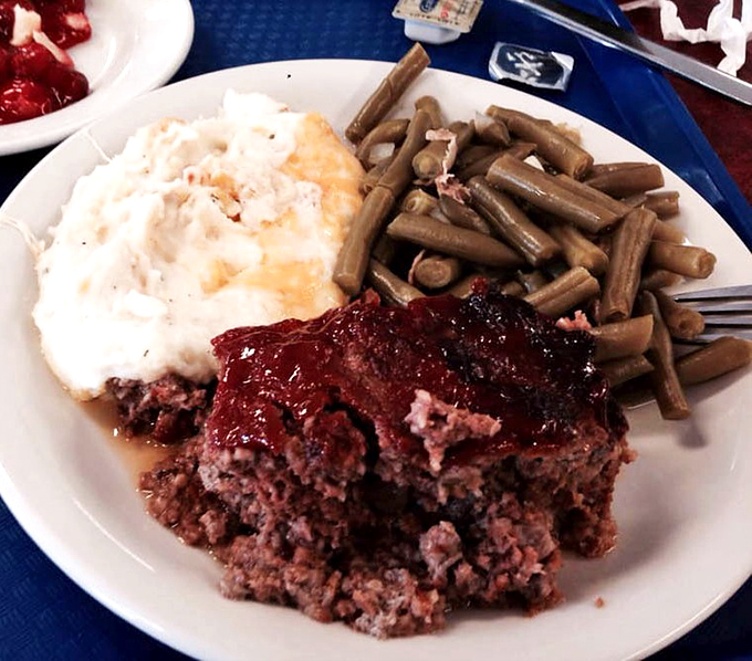 Meatloaf that doesn't apologize for being meatloaf, accompanied by green beans that have clearly been introduced to pork somewhere in their journey.