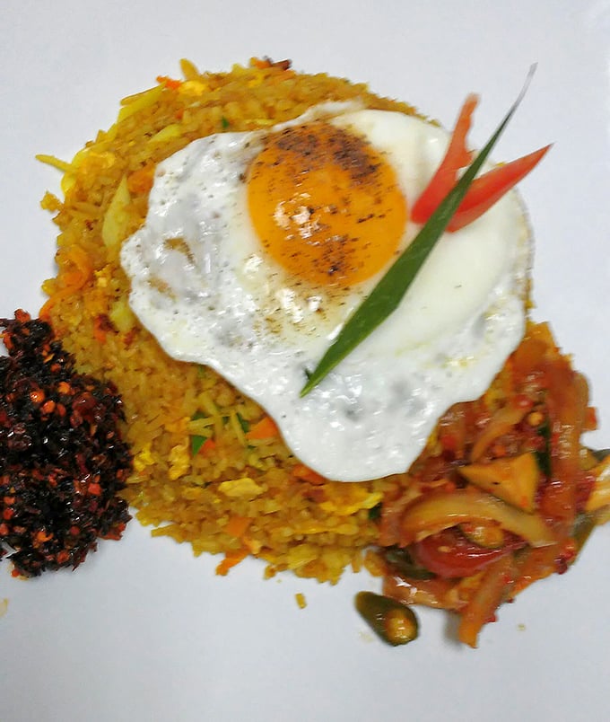 Yellow rice crowned with a perfectly fried egg&mdash;the breakfast of champions meets dinner of kings in this colorful plate of pure comfort.