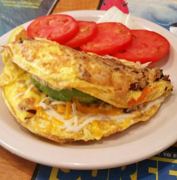 An omelet that doesn't hold back&mdash;stuffed with more fillings than my suitcase on vacation. Those tomato slices add the perfect fresh note.