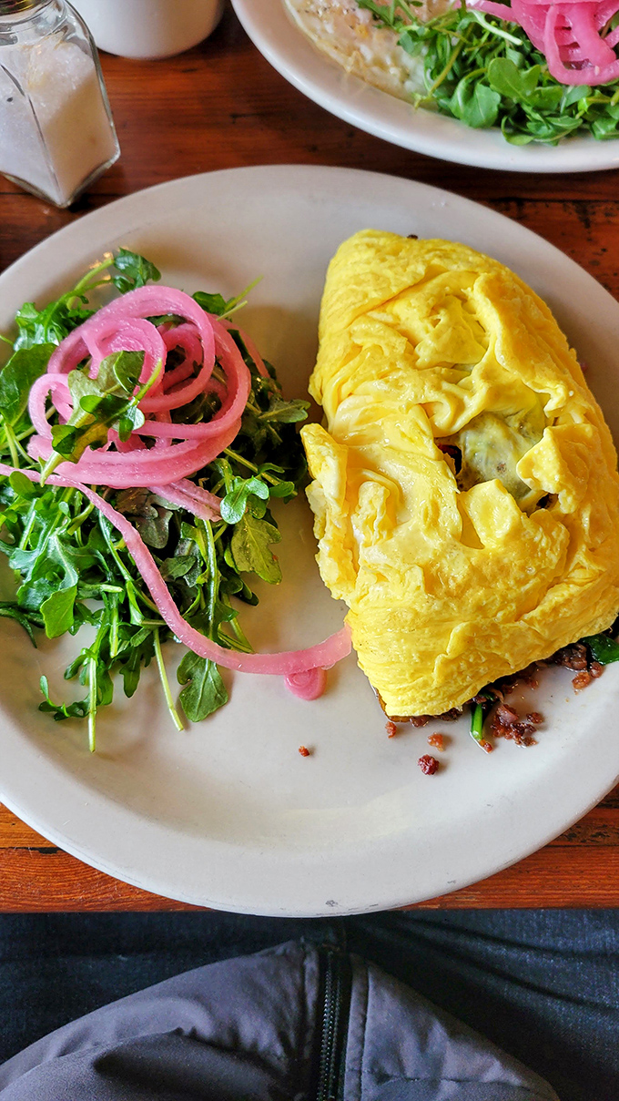 Sunshine on a plate! This fluffy omelet with its perfectly pickled red onions and fresh arugula proves breakfast can be both indulgent and somewhat virtuous.