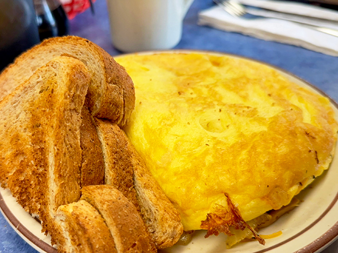 An omelet so perfectly executed it could make a French chef weep with joy, accompanied by toast that knows its supporting role.