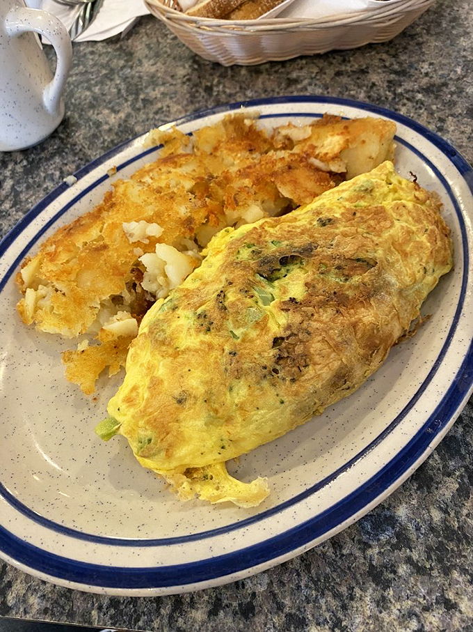 Morning masterpiece: a fluffy omelet alongside home fries that strike the perfect balance between crispy exterior and tender interior.