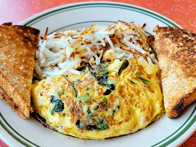 An omelet that refuses to be ordinary&mdash;golden exterior, vibrant vegetables, and hash browns crisped to such perfection they deserve their own fan club.