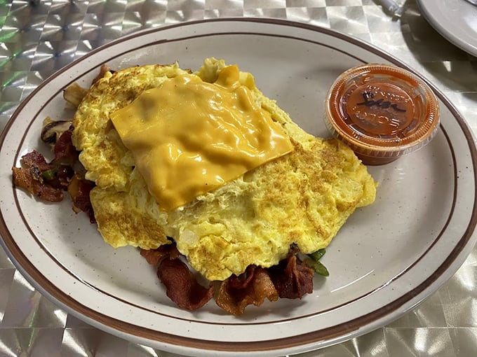 An omelet that doesn't need truffle oil or imported cheese to impress. Just perfectly cooked eggs embracing bacon with melted American cheese on top.