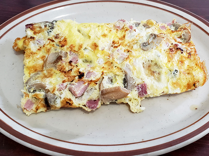This omelet doesn't just contain ham and mushrooms; it celebrates them in a fluffy, golden embrace.