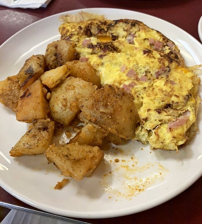 An omelet that's had more fillings than most people have had conversations, nestled beside home fries that crackle with each bite.