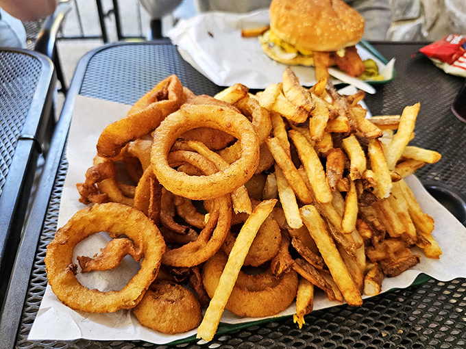 A mountain of hand-cut fries and onion rings that could feed a small hiking party. Carb-loading never looked so gloriously unapologetic.