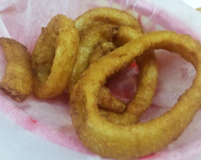 These onion rings aren't just side dishes—they're golden halos of happiness, fried to that perfect crunch that makes time stand still for one glorious moment.