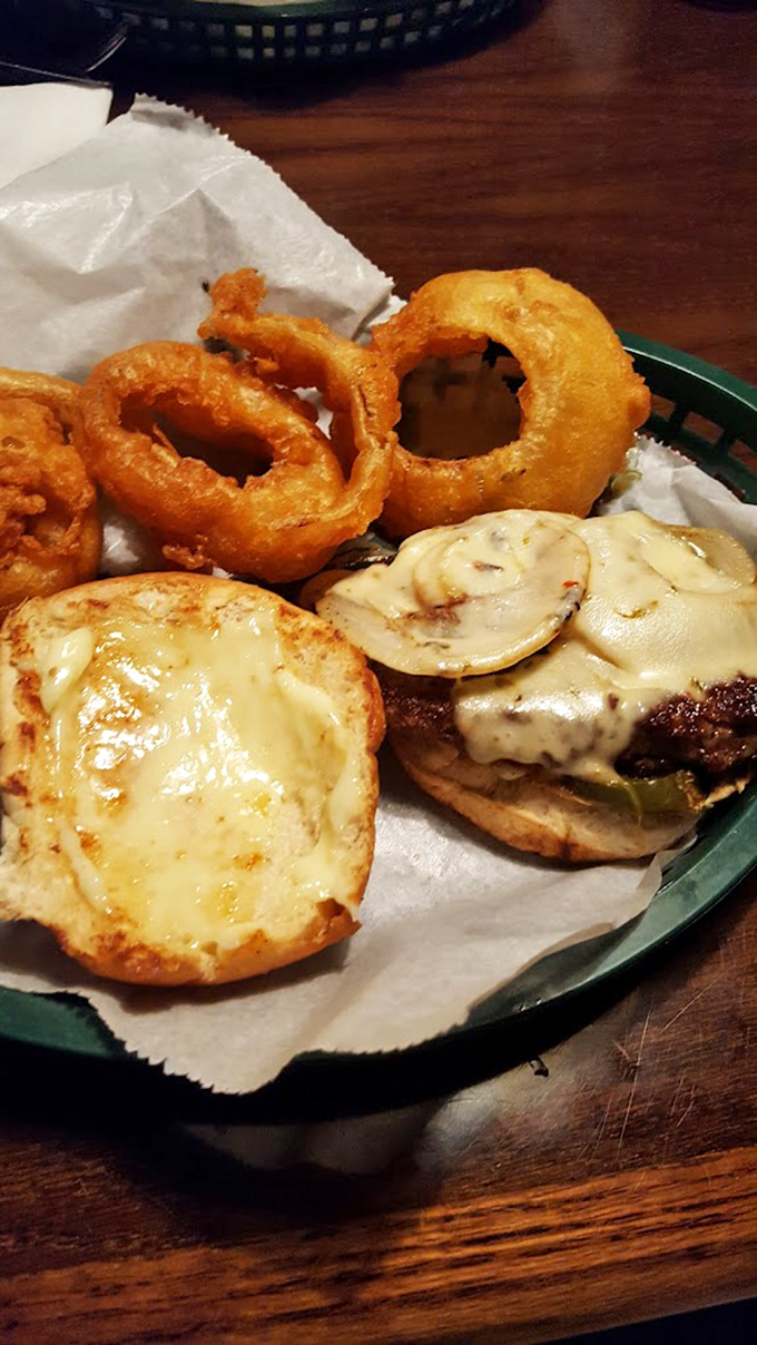 The holy trinity of comfort food: a perfectly melted cheeseburger, golden onion rings, and what appears to be an English muffin pizza experiment gone wonderfully right.
