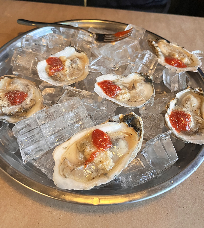 Oysters on the half shell, glistening like jewels on ice. A dash of hot sauce adds the perfect ruby accent to these ocean treasures.