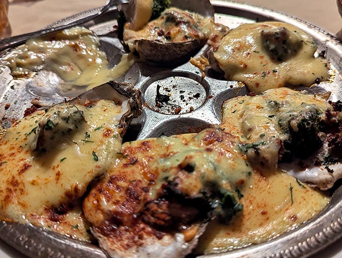 Oysters Rockefeller glistening under their herbed blanket, proving supper clubs can do coastal cuisine with serious style.