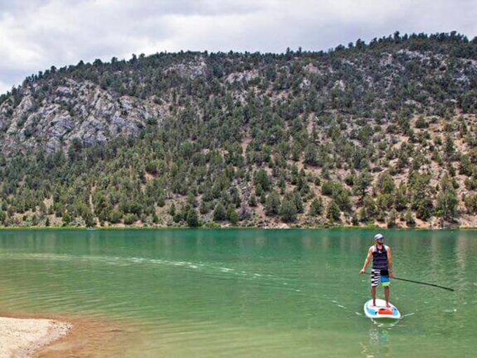 Stand-up paddleboarding at Cave Lake – where falling in means refreshing yourself in waters that look Photoshopped but are gloriously real.