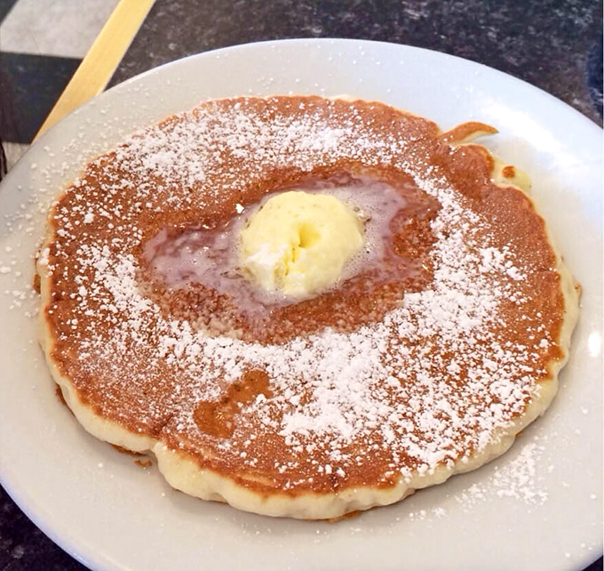 This pancake, dusted with powdered sugar and crowned with melting butter, isn't just breakfast&mdash;it's edible sunshine on a plate.