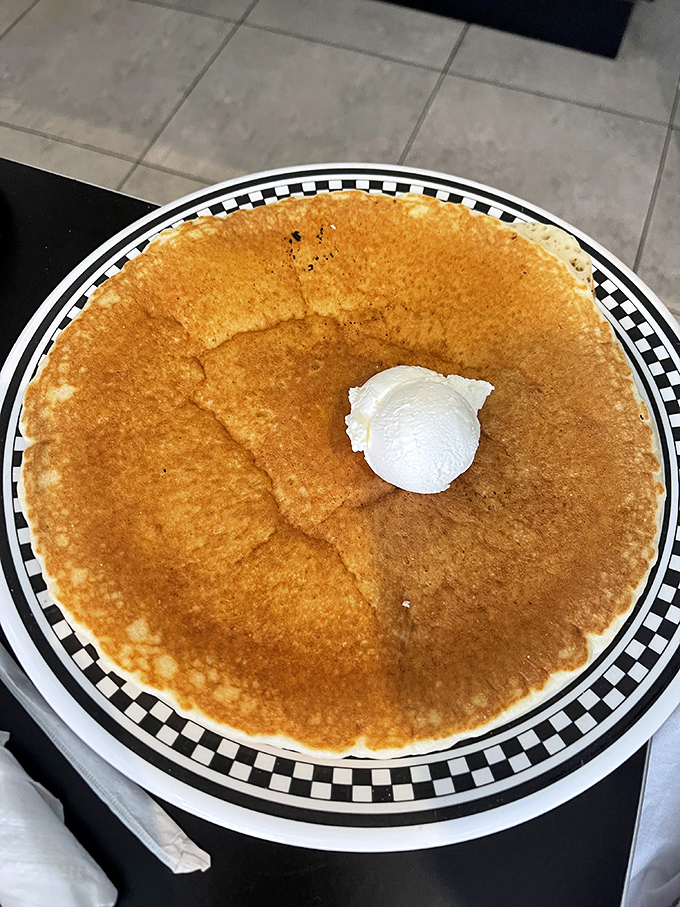 This pancake isn't just large – it has its own gravitational pull. That perfect golden hue is what breakfast dreams are made of.