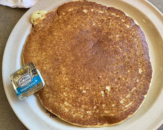The pancake that launched a thousand road trips. Golden-brown, plate-sized, and waiting for its butter bath&mdash;breakfast doesn't get more iconic than this.