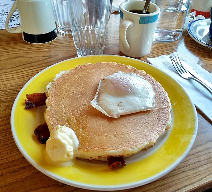 The ultimate breakfast compromise: a giant pancake playing host to a perfectly fried egg&mdash;proof that breakfast diplomacy exists.