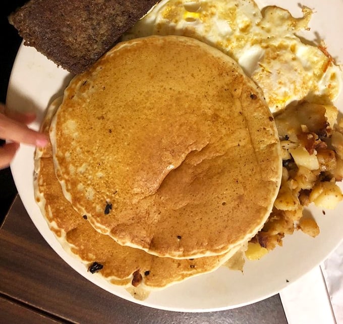 Pancakes stacked higher than your weekend plans, with eggs and home fries playing the perfect supporting roles in this breakfast symphony.