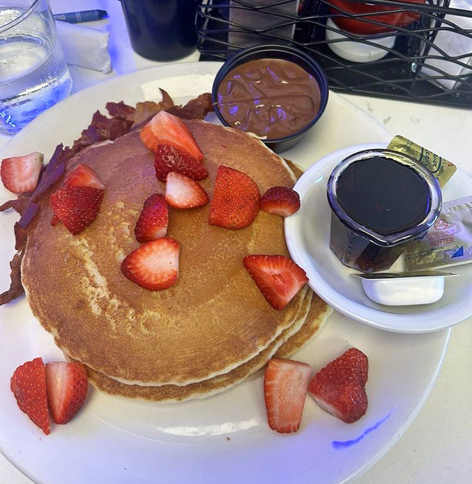 These pancakes don't just arrive at your table – they make an entrance, strawberries playing the role of delicious jewelry.
