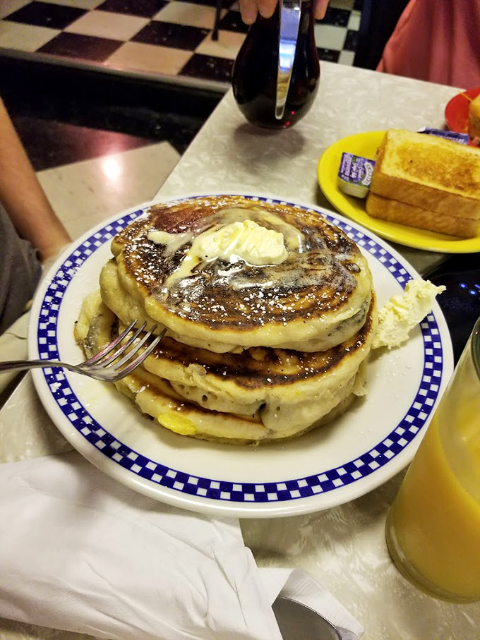 These pancakes aren't just stacked—they're architecturally significant, with butter melting into every nook like a warm morning hug.