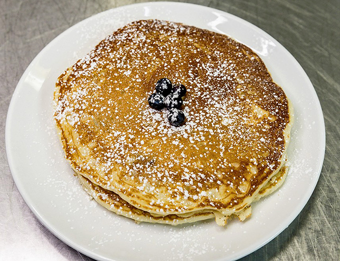 Pancakes dusted with powdered sugar and adorned with blueberries &ndash; nature's candy. Breakfast masquerading as dessert, and nobody's complaining.