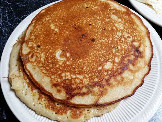These pancakes aren't just round—they're perfect golden discs of happiness that make maple syrup feel like it's found its soulmate.