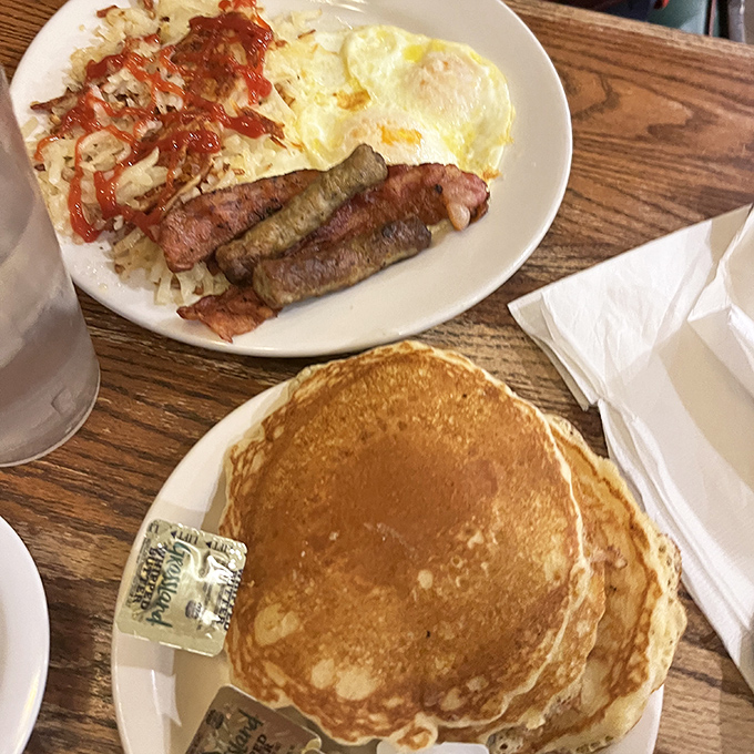 Golden pancakes stacked like delicious vinyl records, ready to play the greatest hits of breakfast alongside sausage links that mean business.