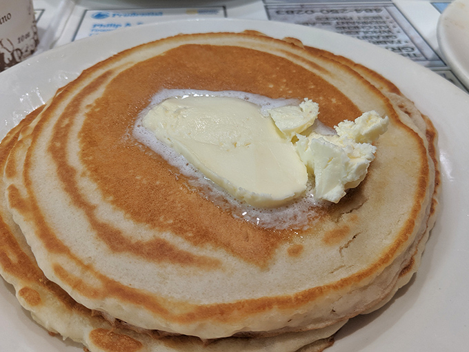 Those pancakes arrive looking like edible clouds with a butter pat melting into submission.