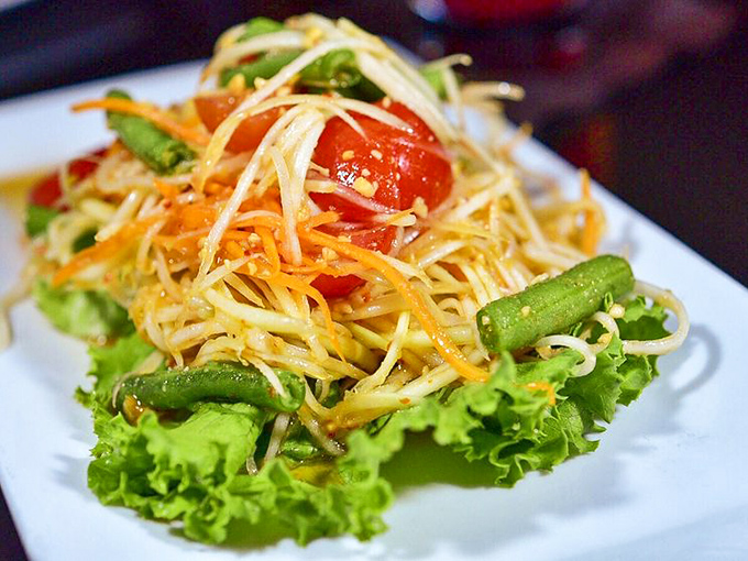 The papaya salad brings such vibrant crunch and zing, it's practically having its own little party on that plate.