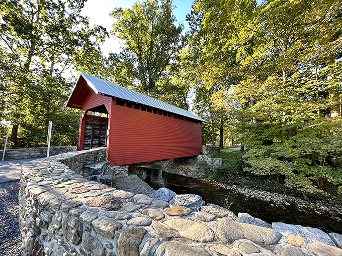 The bridge's vibrant red siding plays peekaboo through the trees, like architectural hide-and-seek in Frederick County's countryside.