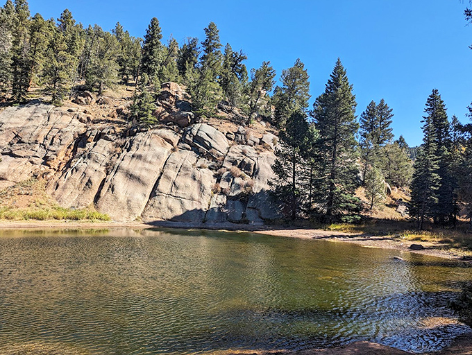 This tranquil pond beneath dramatic rock formations is nature's version of infinity pool meets sculpture garden. Pure Colorado magic.