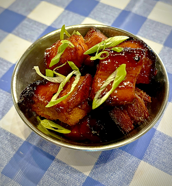 Pork belly bites glistening with glaze and topped with green onions&mdash;proof that sometimes the best things come in small, fatty packages.