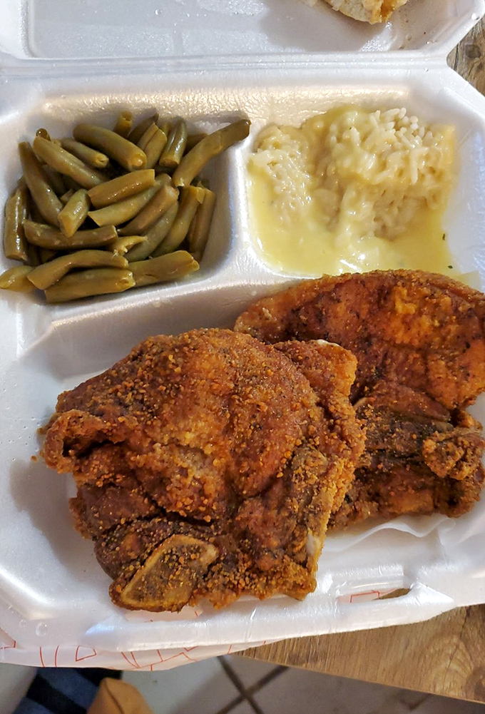 Southern harmony on a plate: crispy pork chop alongside green beans and rice. The kind of meal grandmothers approve of and cardiologists politely ignore.