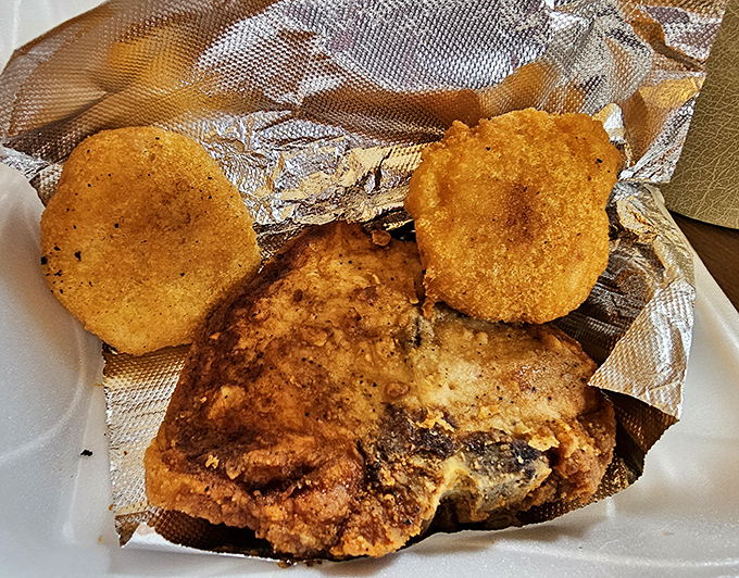 A pork chop that's lived its best life and is now fulfilling its destiny on your plate, alongside those perfect golden discs of hot water cornbread.