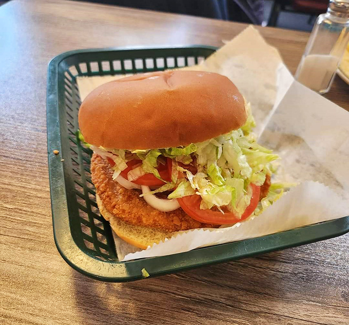 This pork tenderloin sandwich refuses to acknowledge the boundaries of its bun, a Midwestern statement piece worth every bite.