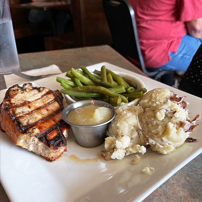 A perfectly grilled pork chop with green beans and loaded mashed potatoes&mdash;proof that simple food done right is culinary poetry.