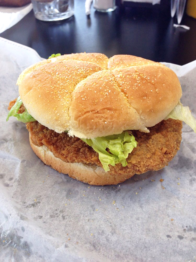 The pork tenderloin sandwich extends beyond its bun like a crispy halo. This Midwest classic demands both hands and your full attention.