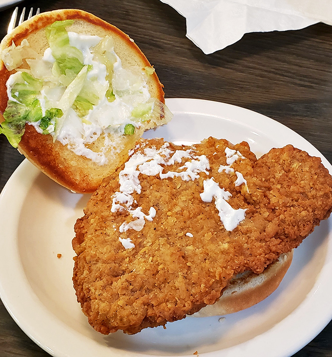 This pork tenderloin sandwich has clearly won the "bigger than your face" competition, with crispy edges spilling beyond the bun.