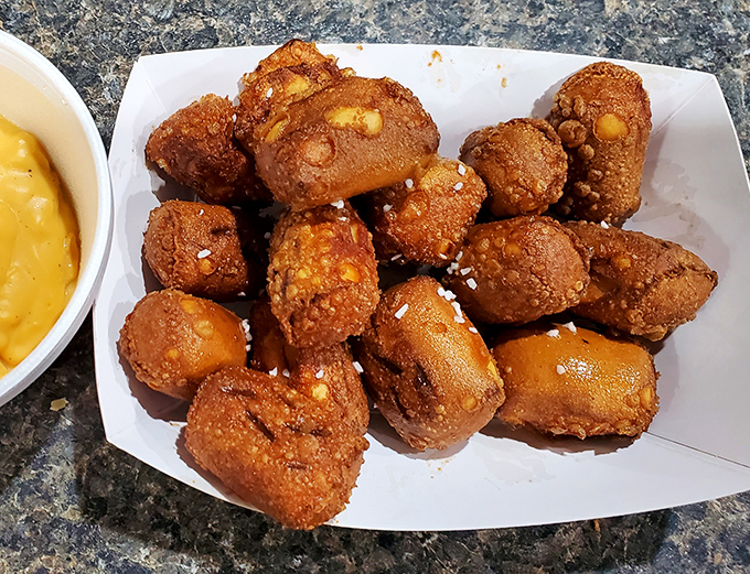 These golden-brown pretzel bites look like they're auditioning for the snack food hall of fame, with cheese sauce as their enthusiastic agent.