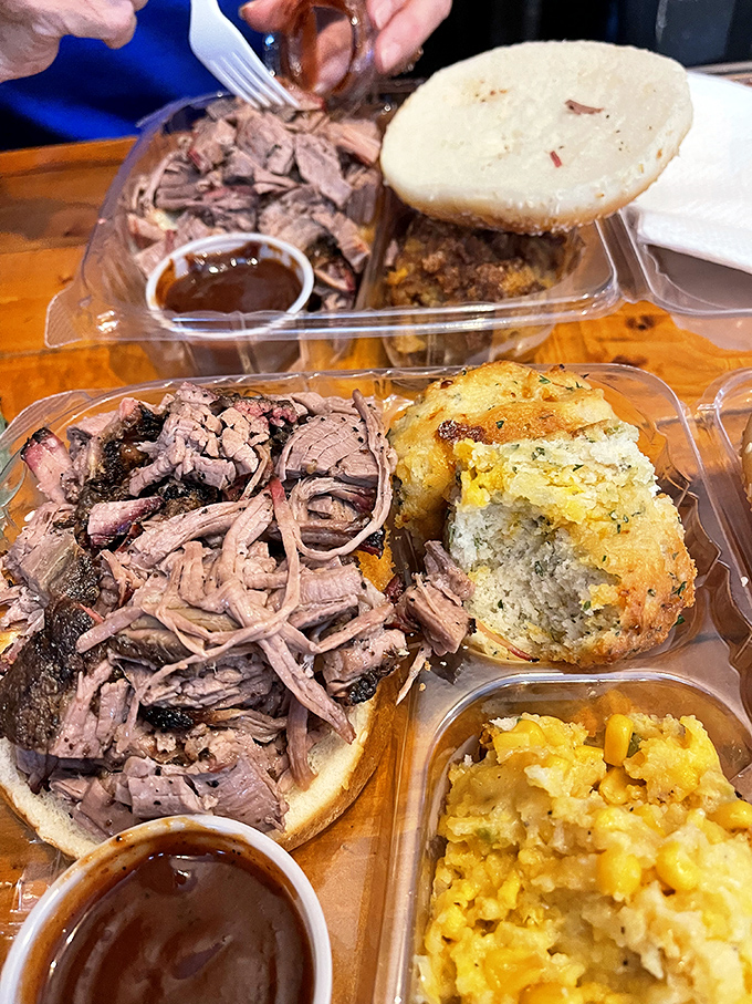 This pulled pork sandwich with cornbread and mac and cheese is what comfort food dreams are made of. The sauce cup is standing by like a faithful sidekick.