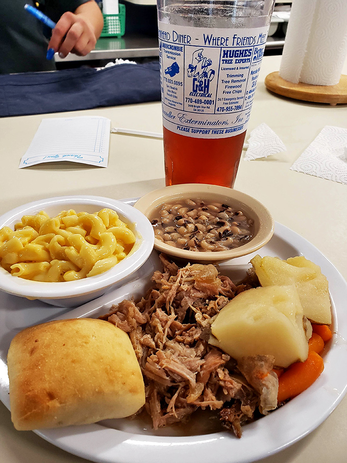 A proper pulled pork plate with all the fixings—proof that diners understand comfort food isn't just for breakfast hours.