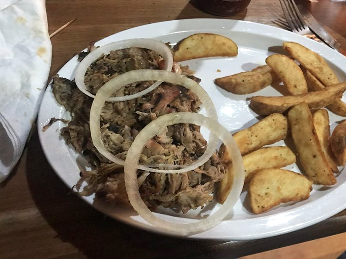 Pulled pork that's had a proper introduction to smoke and seasoning, topped with rings of raw onion for that perfect flavor contrast.