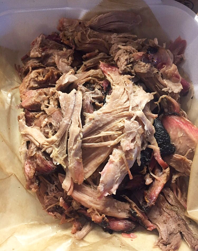 Pulled pork in its natural habitat—tender strands with bits of bark that create the textural symphony barbecue dreams are made of.