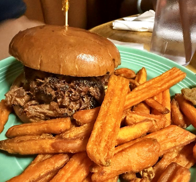 A pulled pork sandwich that doesn't just speak to you – it serenades your taste buds with a meaty love song, accompanied by golden fries that crunch like autumn leaves.