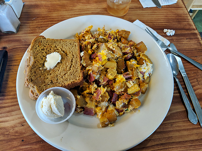 Comfort on a plate: hearty bread alongside home fries that have clearly been introduced to cheese, bacon, and eggs under the happiest of circumstances.
