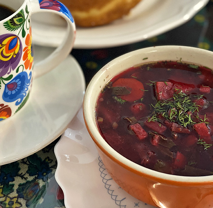 The vibrant ruby-red borscht garnished with fresh dill is like Eastern Europe in a bowl – earthy, bright, and utterly soul-warming.